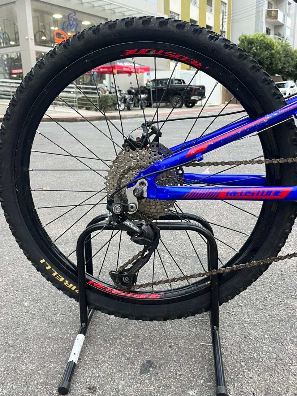 BICICLETA ARO (24) AZUL/VERMELHA 9 VELOCIDADES (1X9) FREIO A DISCO MECÂNICO REDSTONE (USADA ...